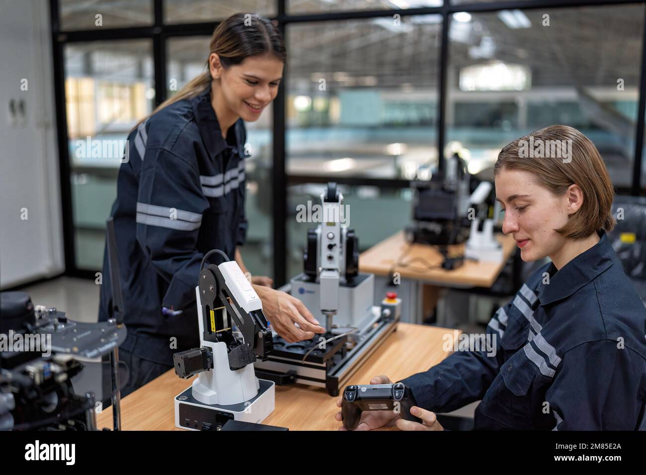 Girl engineer sitting in robot fabrication room quality checking ...
