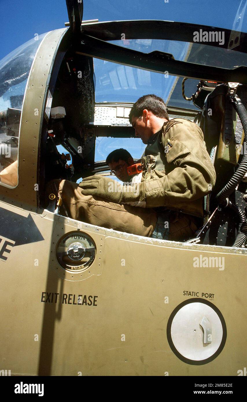 A U.S. Army pilot and copilot secure themselves in the cockpit of an OV ...