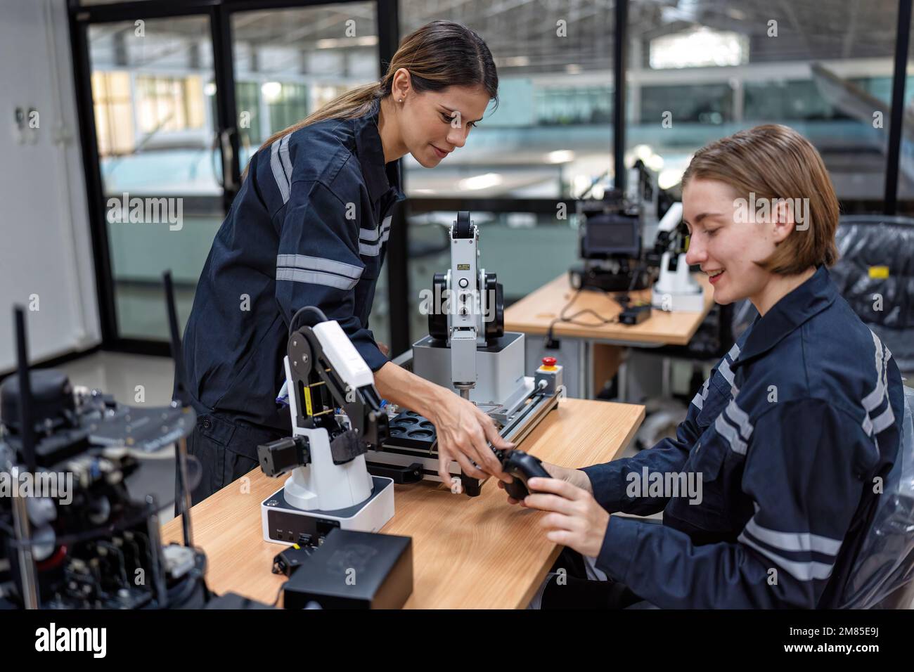 Girl engineer sitting in robot fabrication room quality checking ...