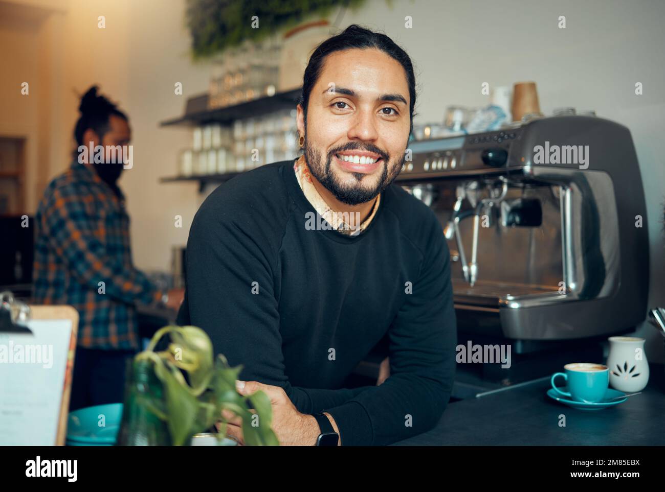 Portrait, coffee shop and barista with a man at work behind the counter ...