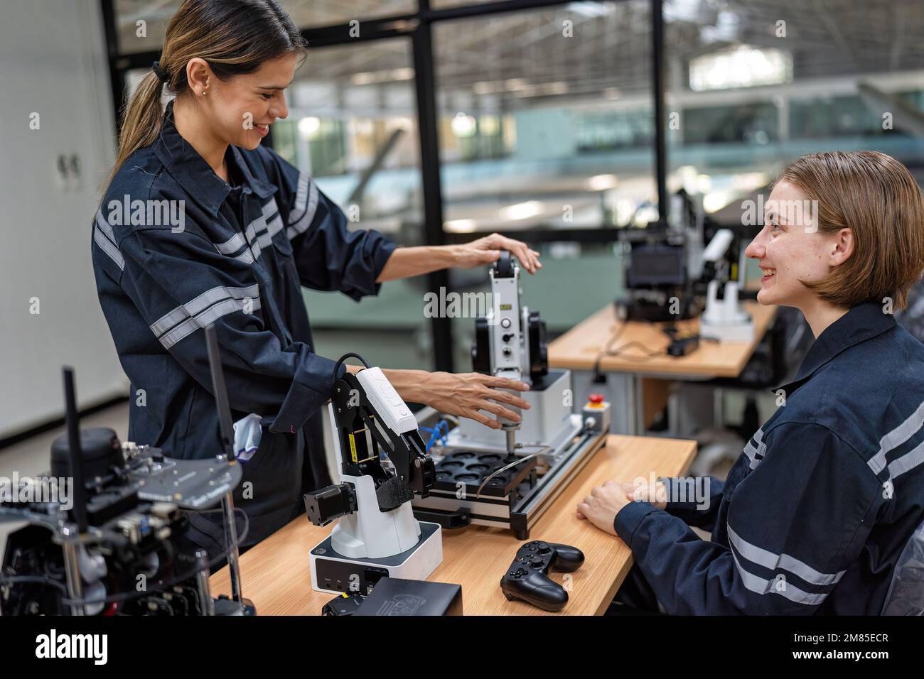 Girl engineer sitting in robot fabrication room quality checking ...