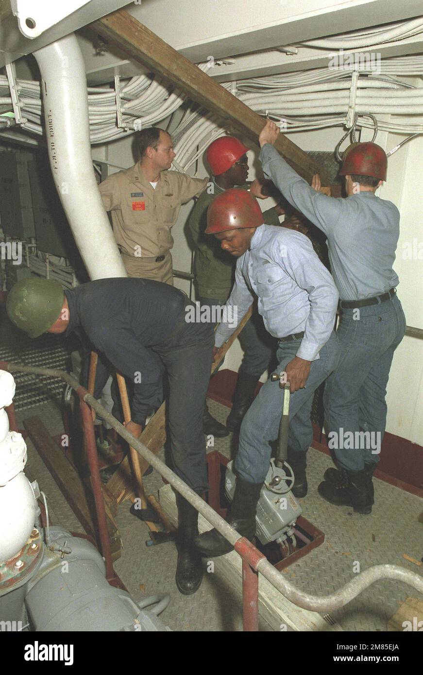 A damage control repair party shores a bulkhead during a general ...