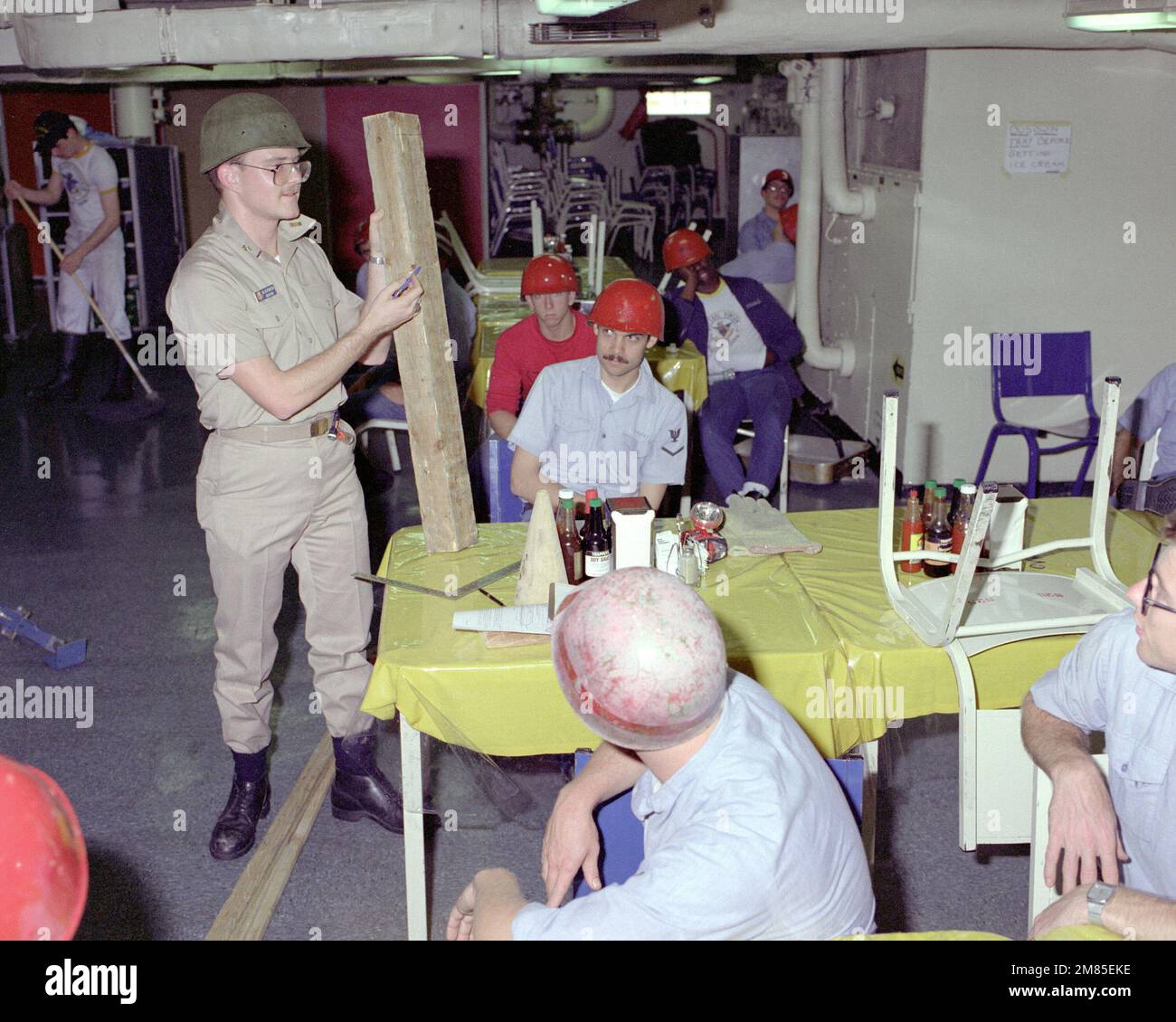 A training officer instructs members of a damage control party in ...