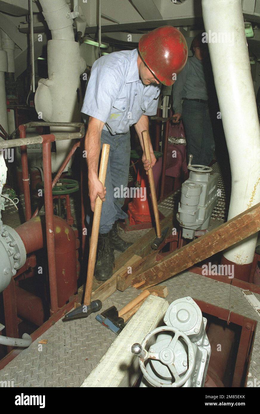 A damage control repair party assists in shoring a bulkhead during a ...