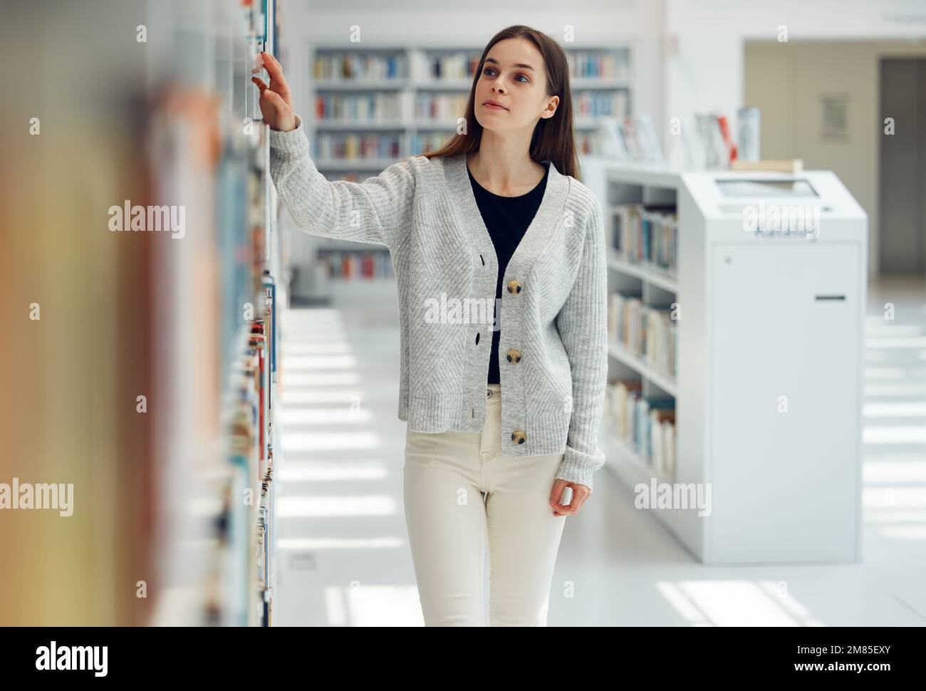 Woman, student and library for books, knowledge or learning at the ...