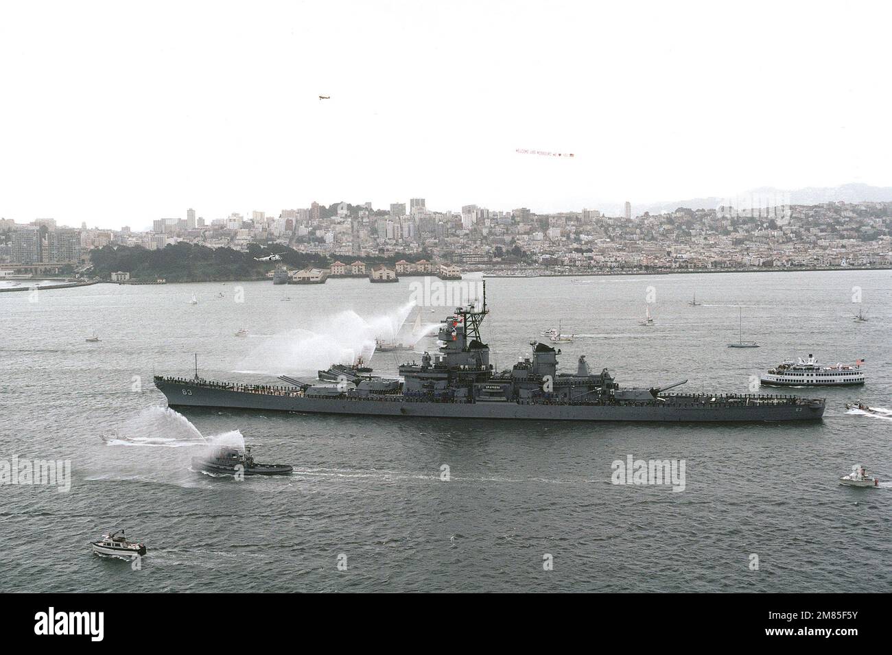 Tugs spray water into the air as the battleship USS MISSOURI (BB-63 ...