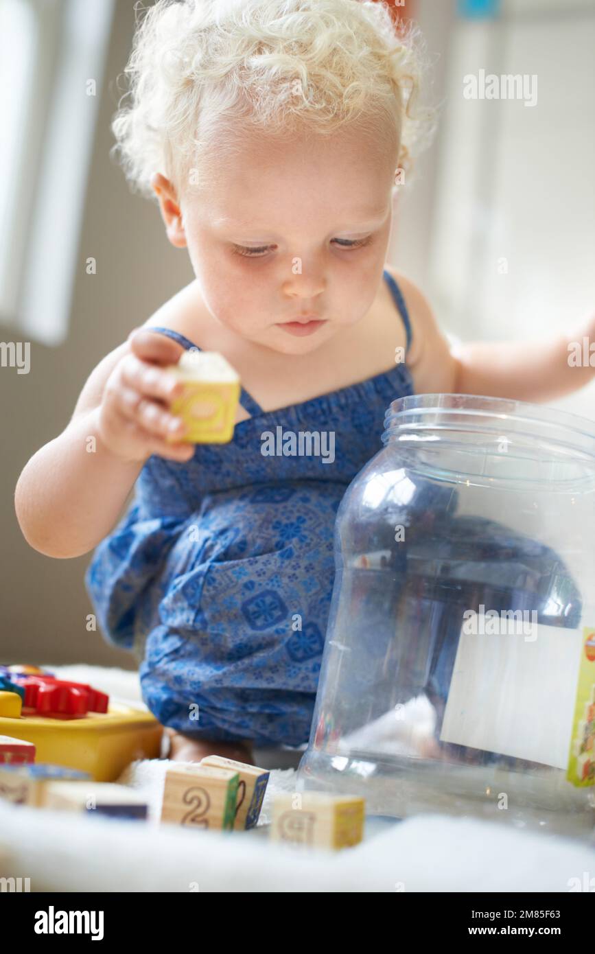 The building blocks of development. A sweet little baby girl playing ...