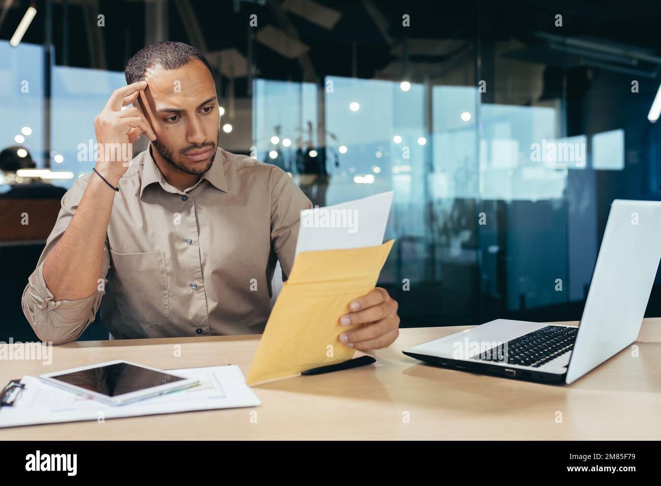 Pensive businessman inside office reading notification letter, man ...