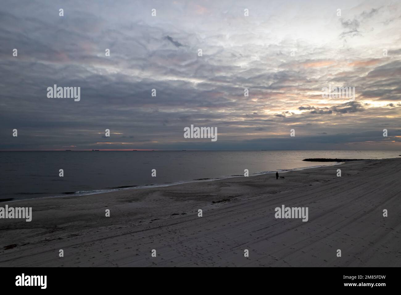 A drone shot of the sandy Long Beach under cloudy dusk sky in New York ...