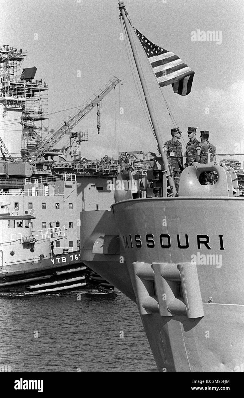 Marine Corps personnel raise the colors on the fantail of the ...