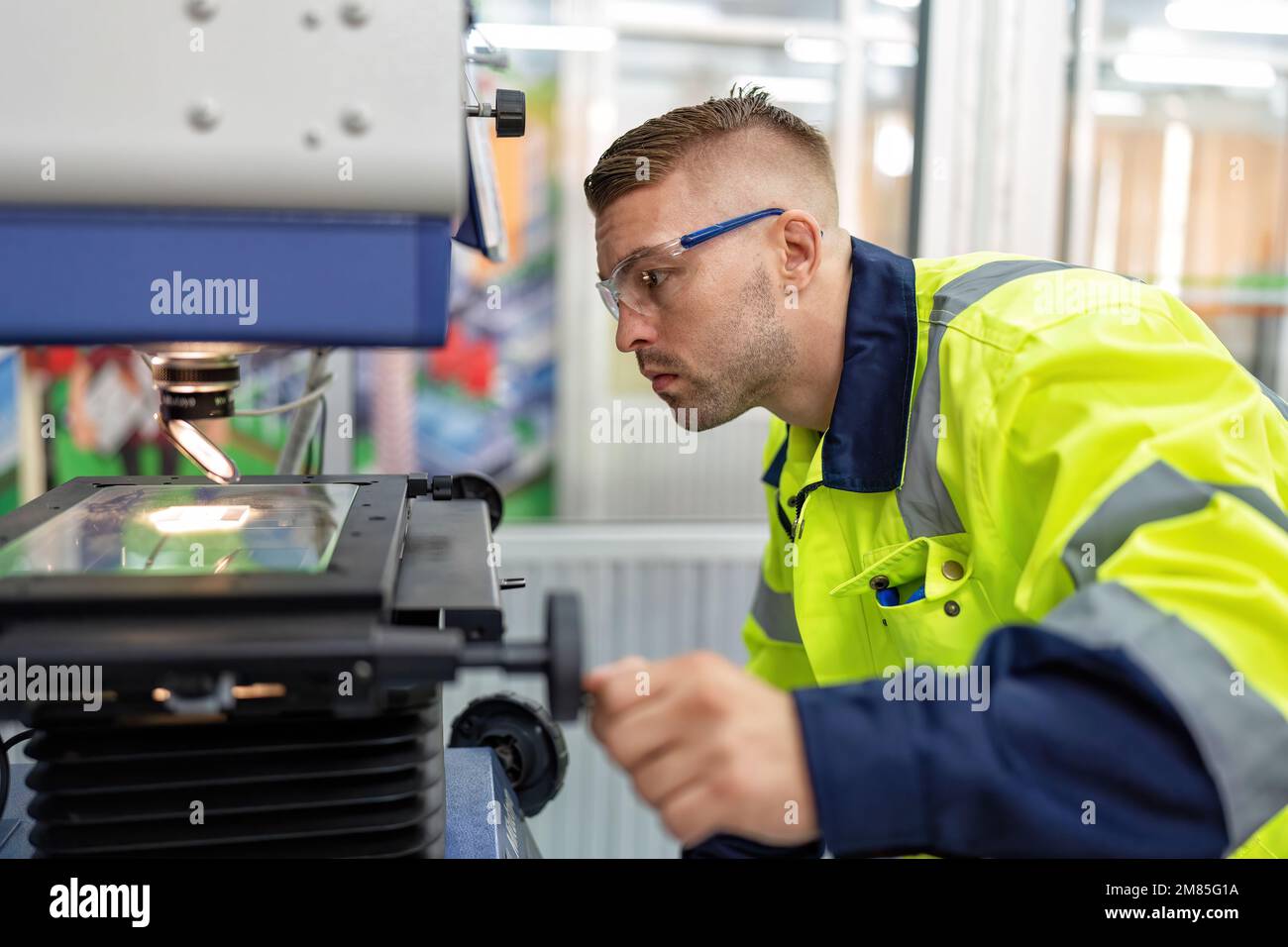 Engineer sitting in robot fabrication room use measuring microscope ...