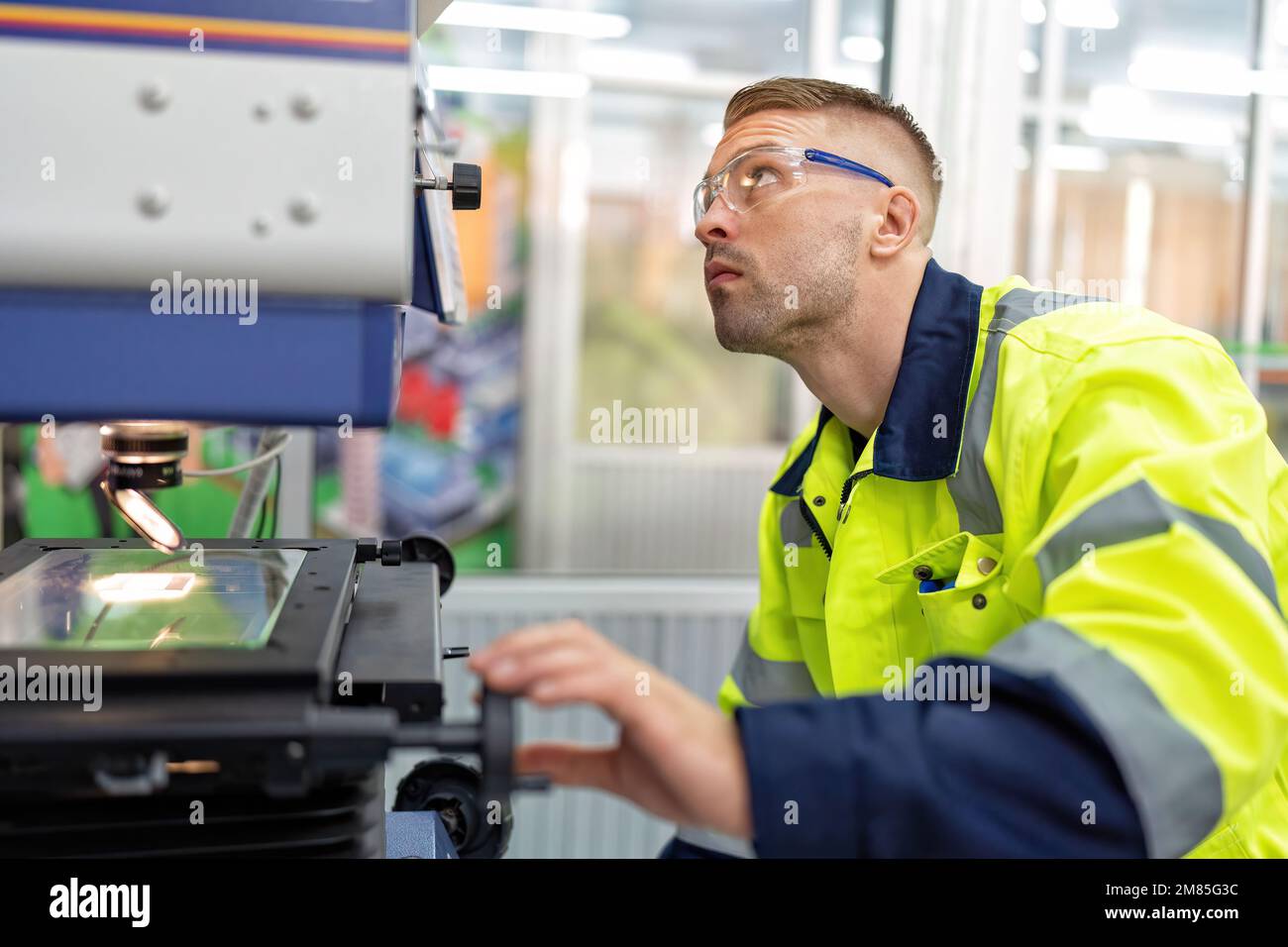 Engineer sitting in robot fabrication room use measuring microscope ...