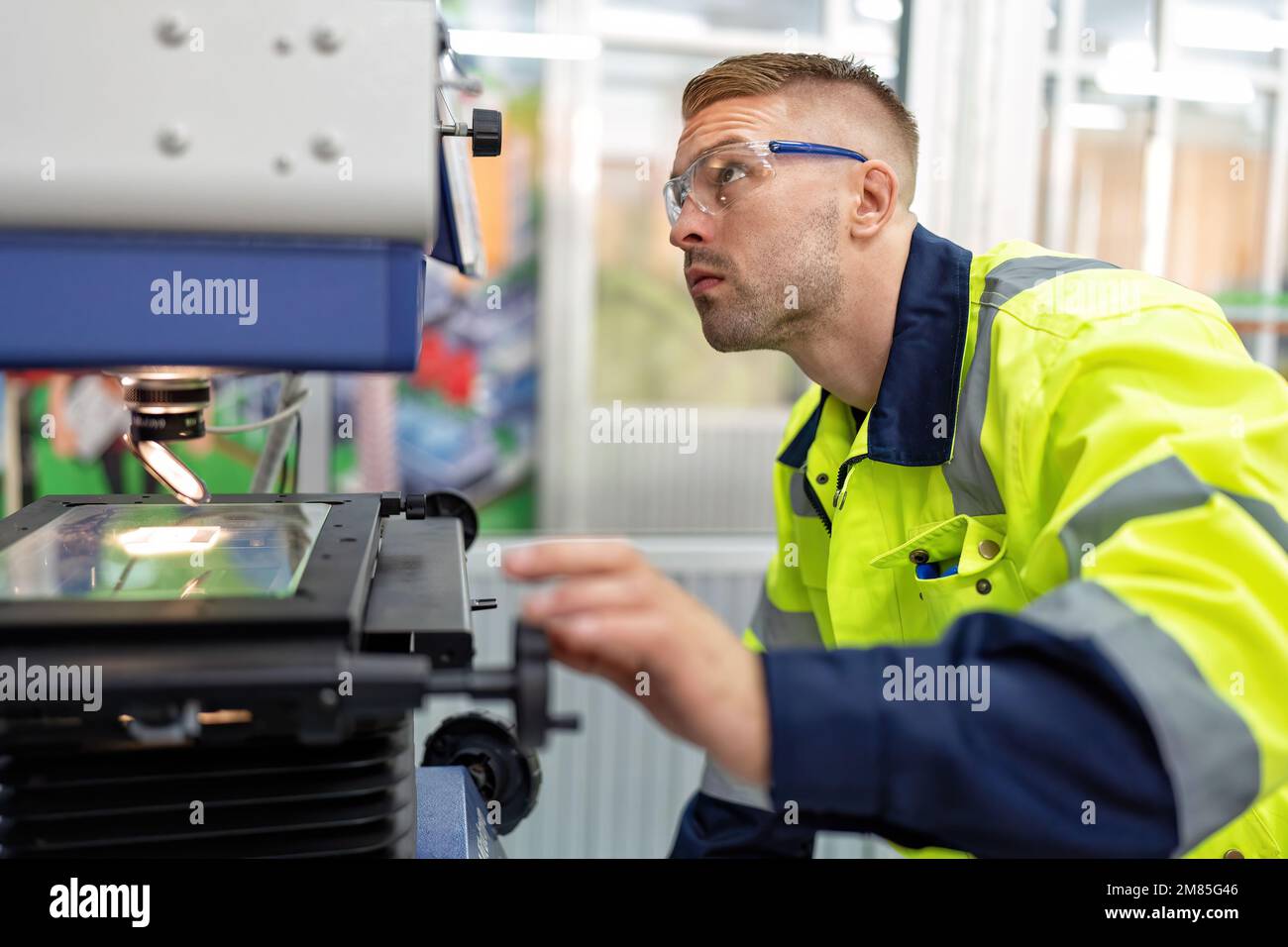 Engineer sitting in robot fabrication room use measuring microscope ...