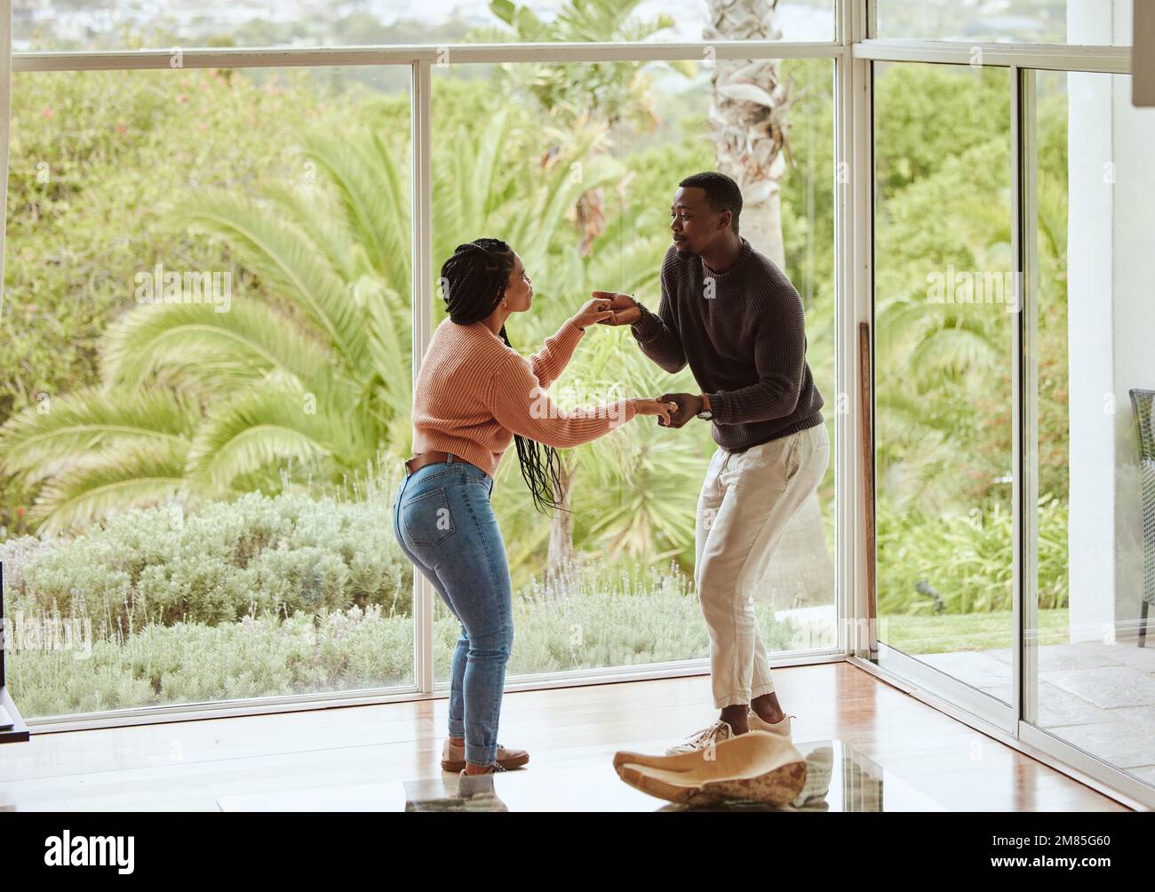 Black couple, dancing and celebration in their new home with love while excited and happy in a ...