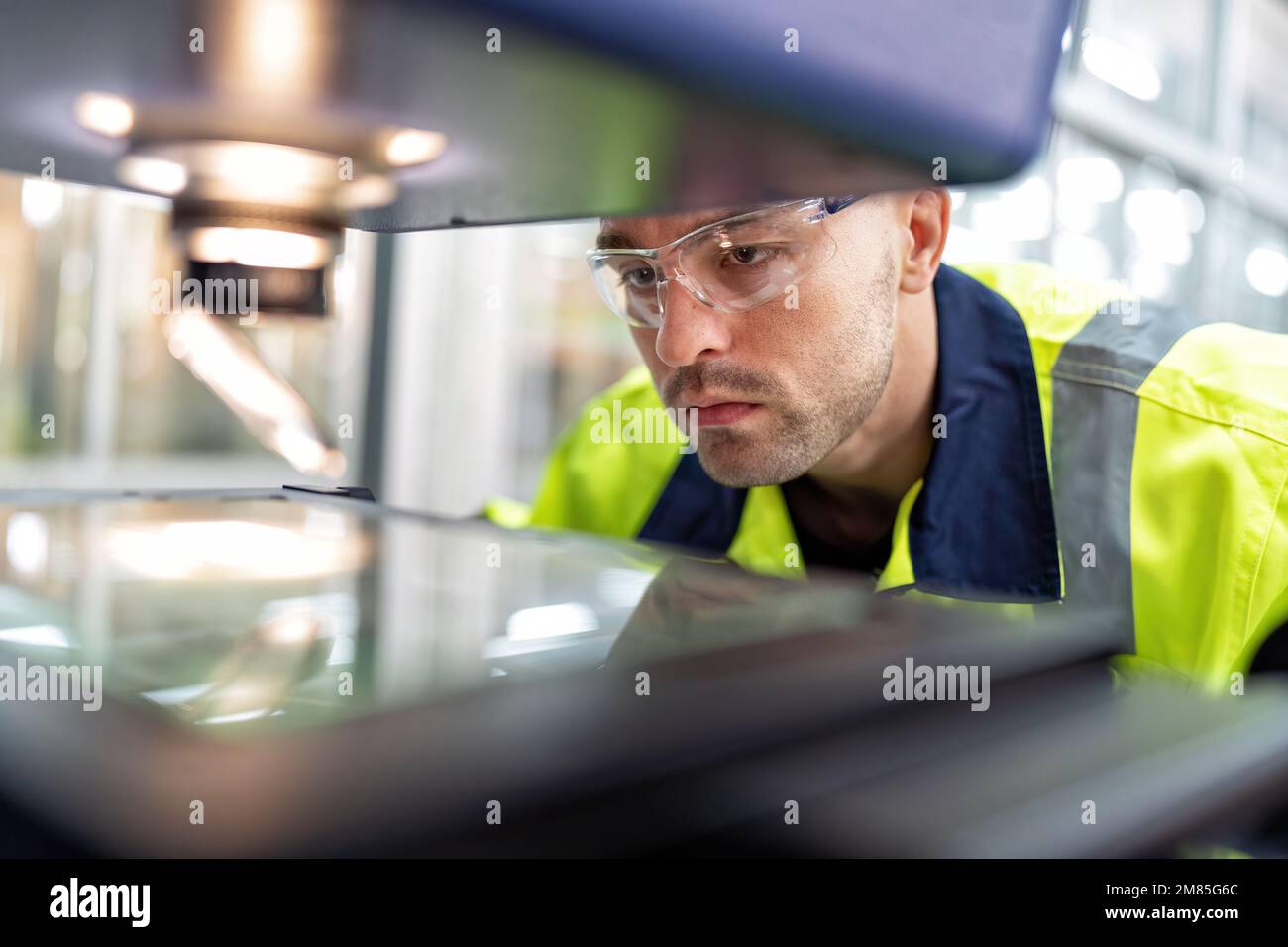 Engineer sitting in robot fabrication room use measuring microscope ...