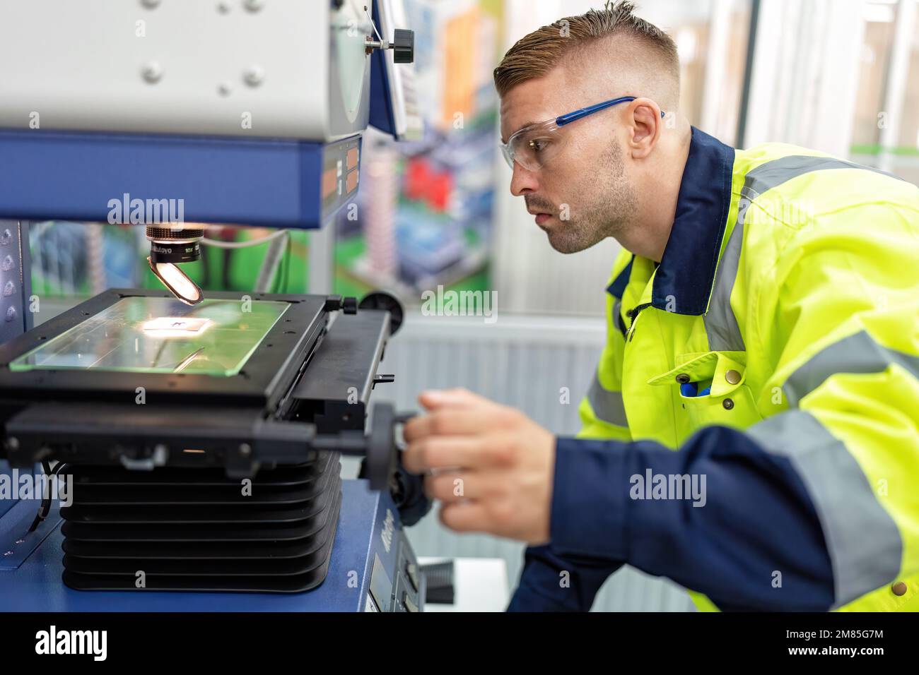 Engineer sitting in robot fabrication room use measuring microscope ...