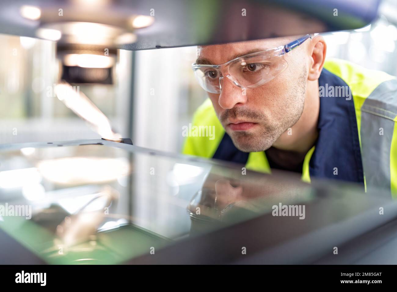 Engineer sitting in robot fabrication room use measuring microscope ...