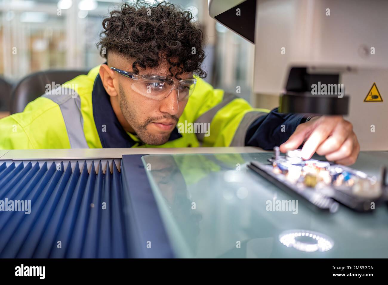 Engineer sitting in robot fabrication room use measuring microscope ...