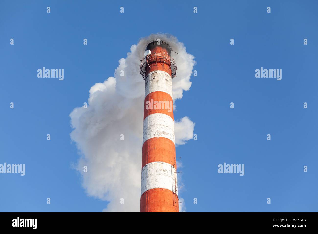 White thick smoke from the boiler room chimney. Smoke against the blue ...