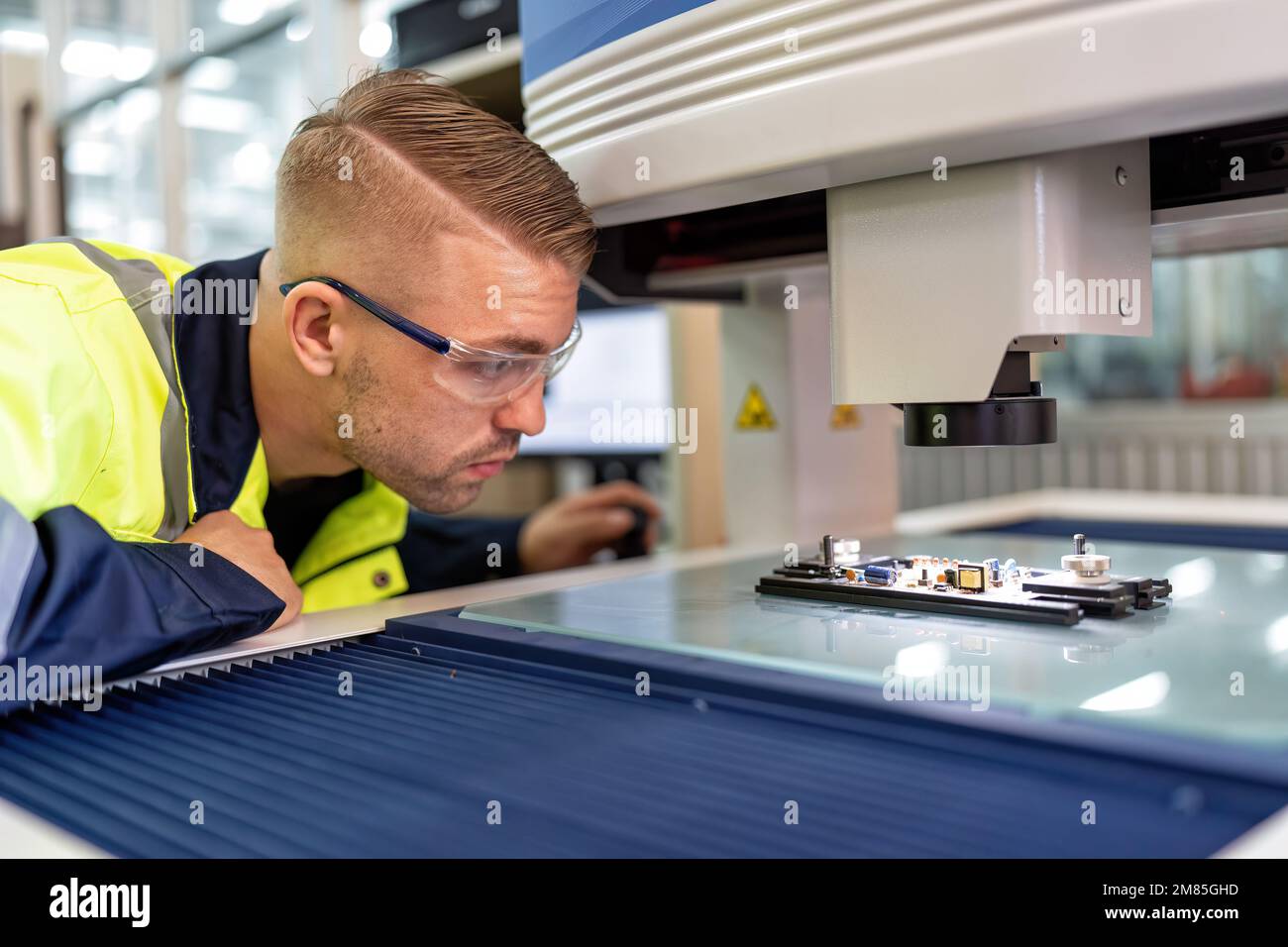 Engineer sitting in robot fabrication room use measuring microscope ...