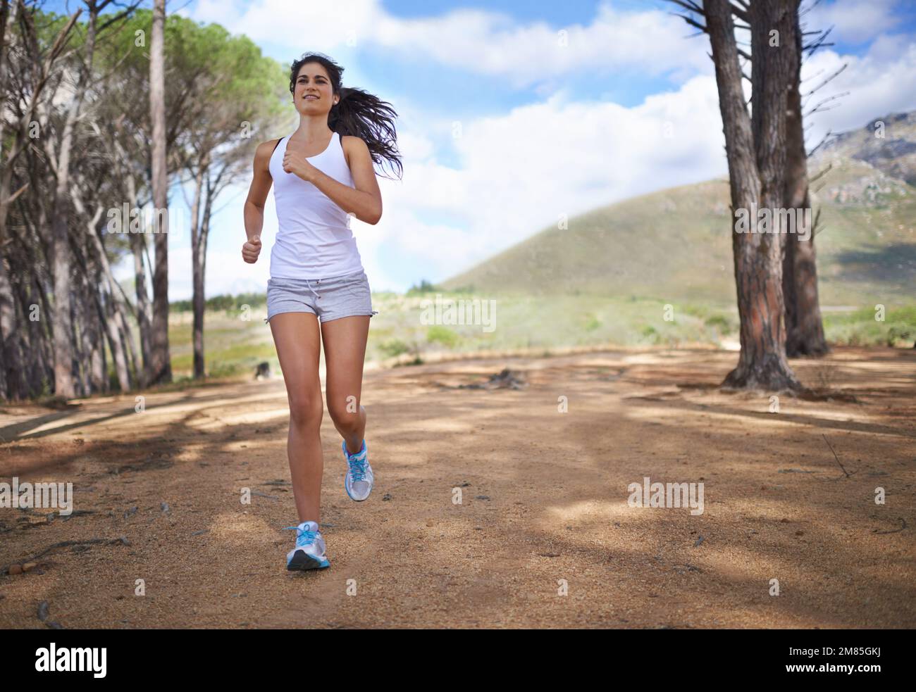 Exploring nature while keeping fit. A young female runner jogging ...
