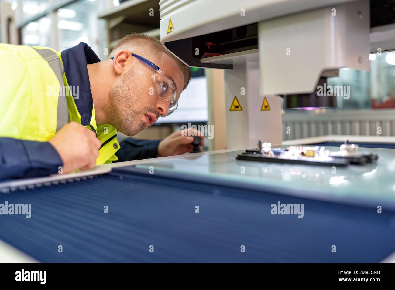 Engineer sitting in robot fabrication room use measuring microscope ...