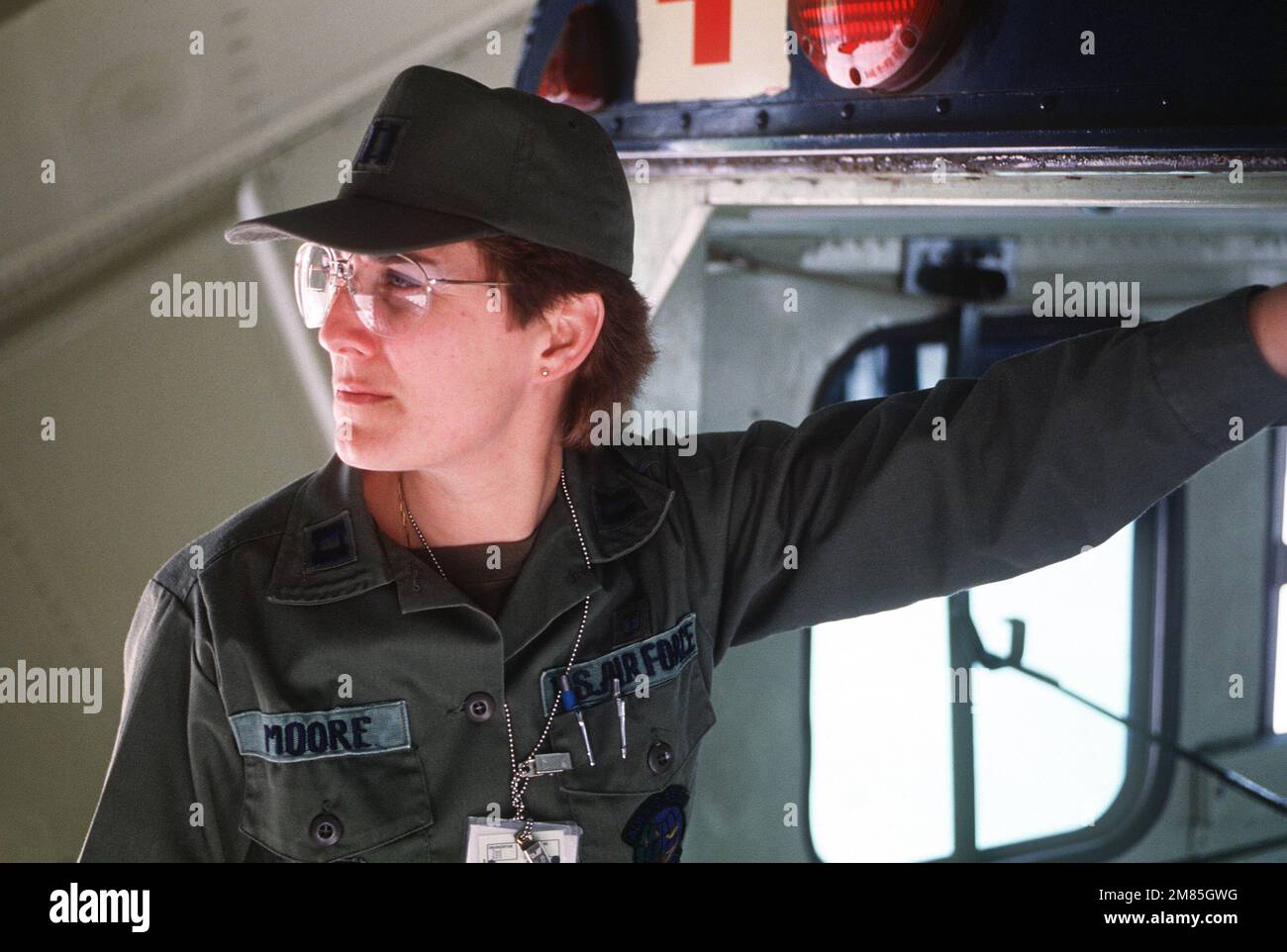 An officer stands by at the rear of an ambulance positioned beside the ...