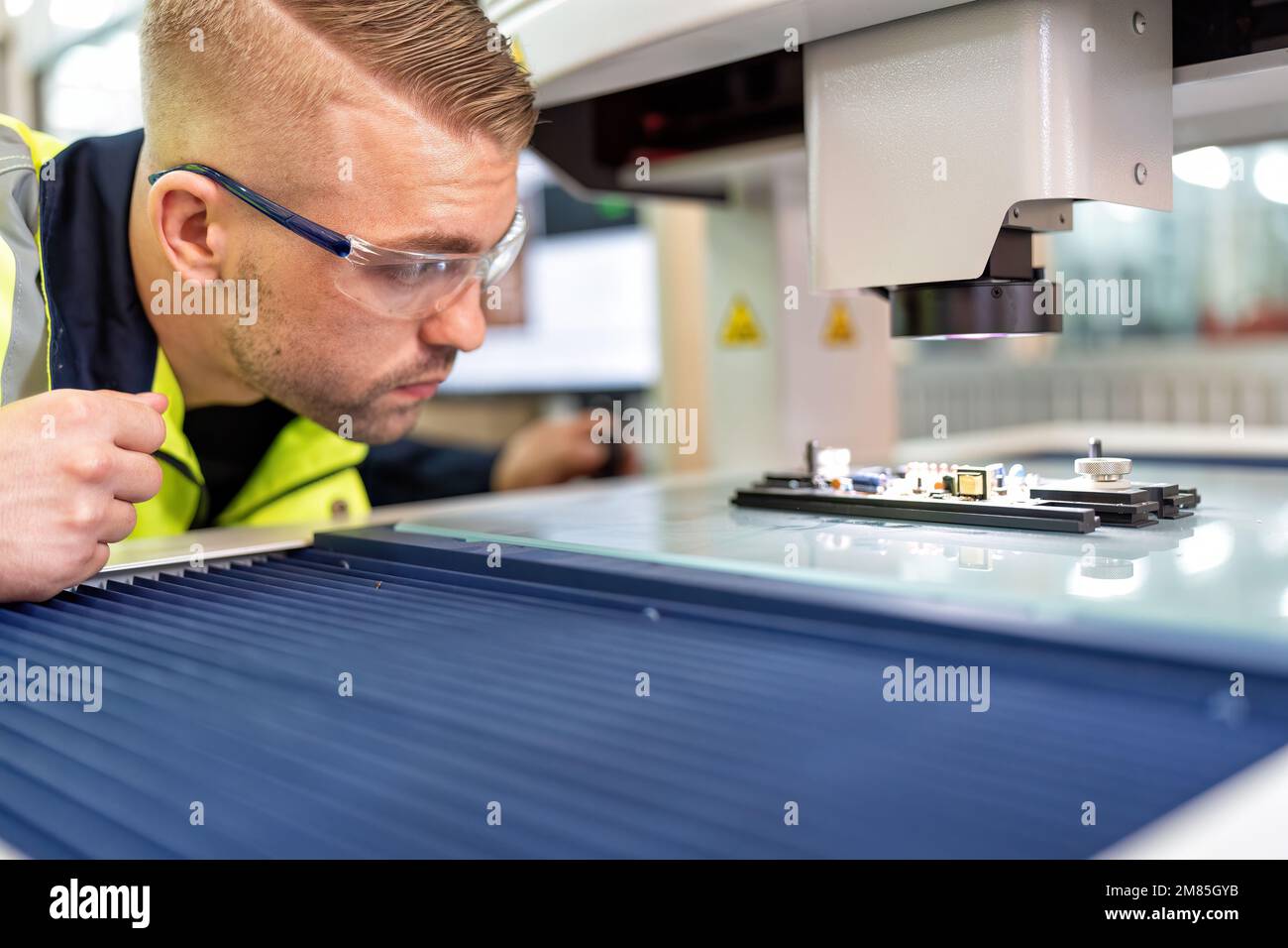 Engineer sitting in robot fabrication room use measuring microscope ...