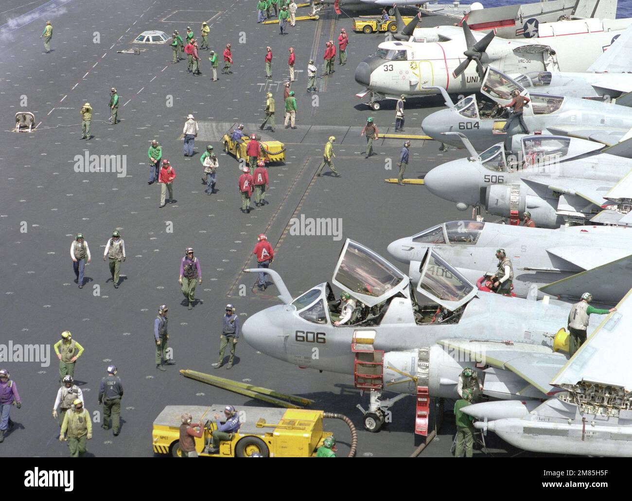 An EA-6B Prowler and other aircraft are serviced on the flight deck ...