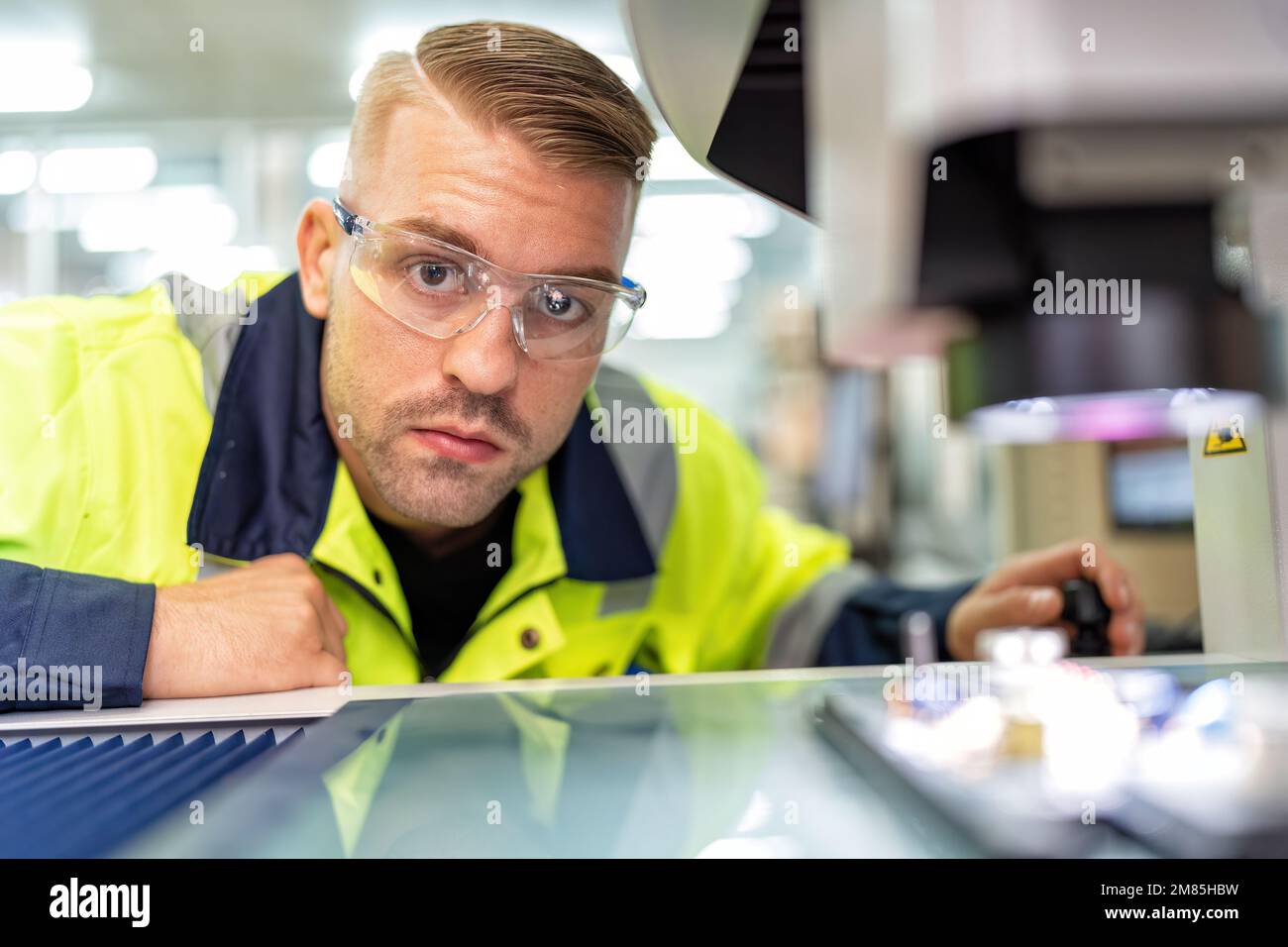 Engineer sitting in robot fabrication room use measuring microscope ...