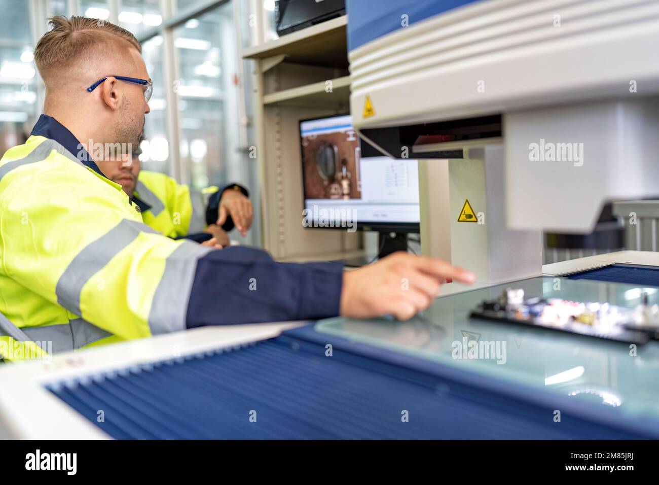 Engineer sitting in robot fabrication room use measuring microscope ...