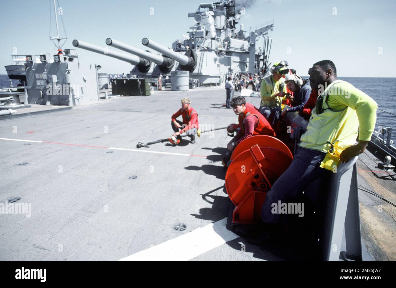 Crewmen stand by on the flight deck aboard the battleship USS IOWA (BB ...