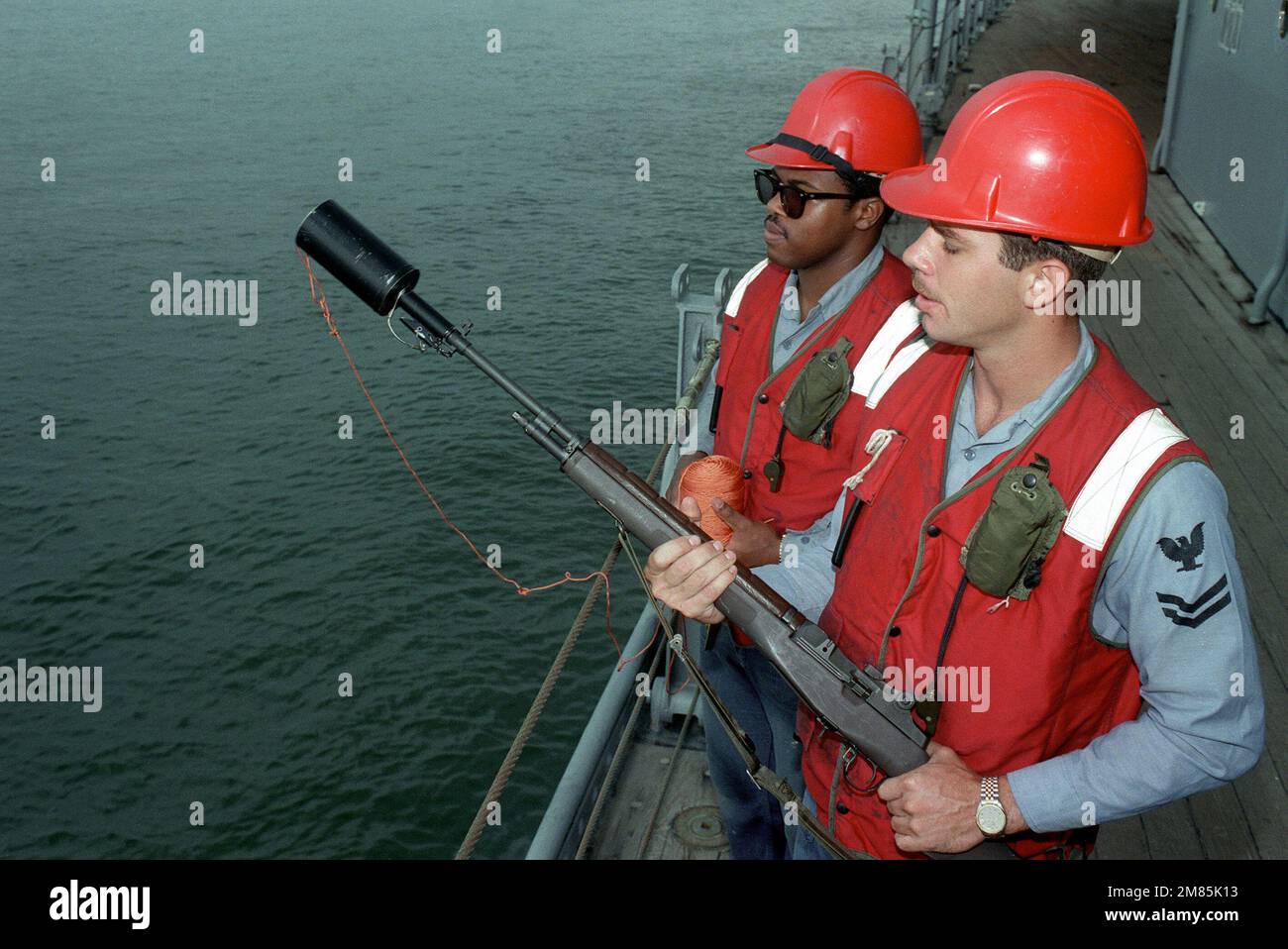 A crewman aboard the battleship USS IOWA (BB-61) prepares to fire a ...