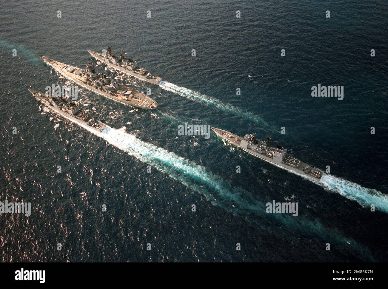 An aerial port quarter view of the destroyer USS DEYO (DD-989); left; the battleship USS IOWA ...