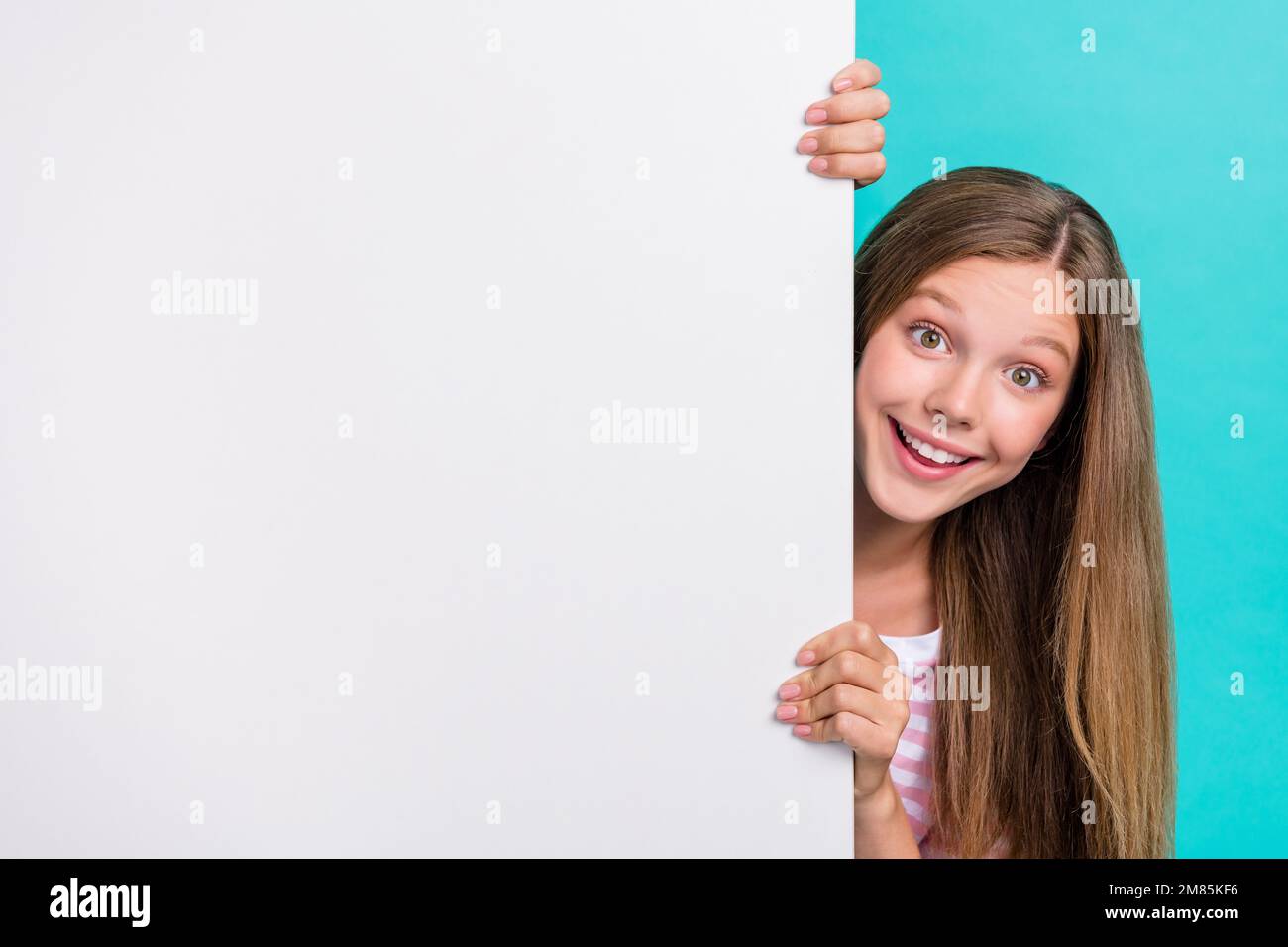 Portrait of cheerful funky person peeking behind empty space ...