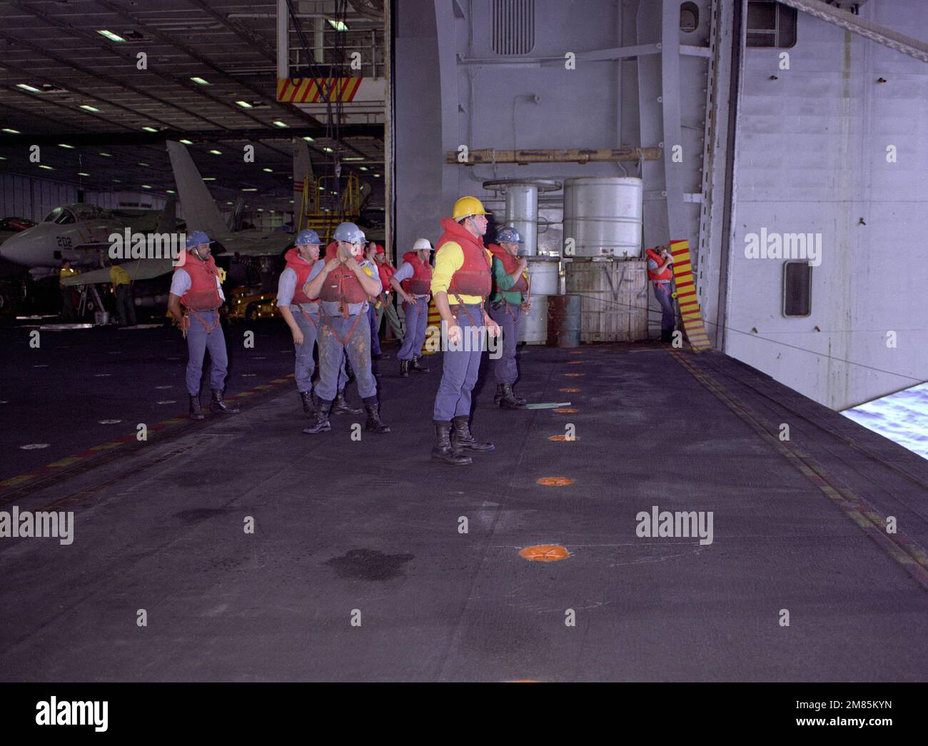 Crew members stand by aboard the nuclear-powered aircraft carrier USS ...