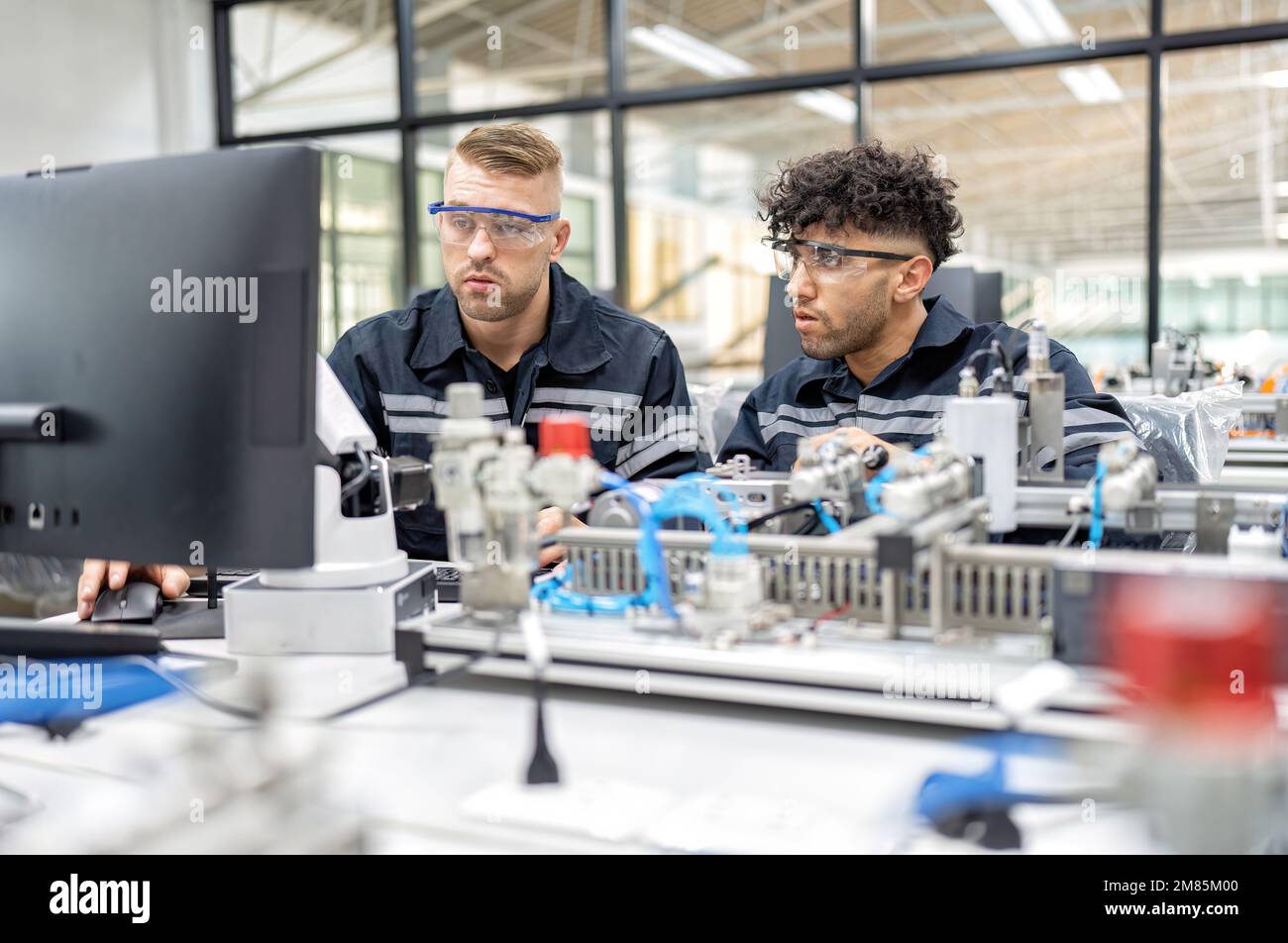 Engineer sitting in robot fabrication room quality checking electronic ...