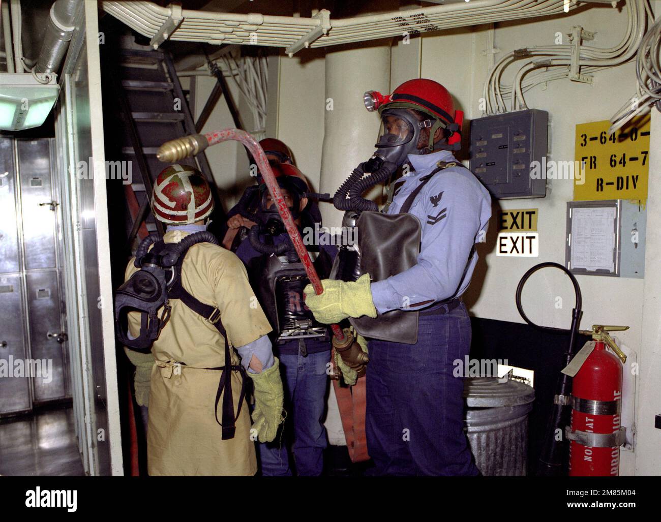 Members of a damage control party wear oxygen breathing apparatus while ...