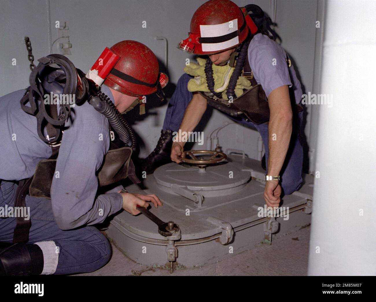 Members of a damage control party secure a hatch during a general ...