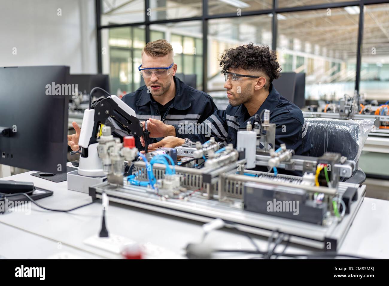Engineer sitting in robot fabrication room quality checking electronic ...