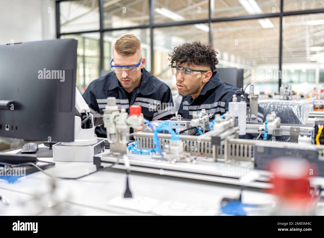 Engineer sitting in robot fabrication room quality checking electronic ...