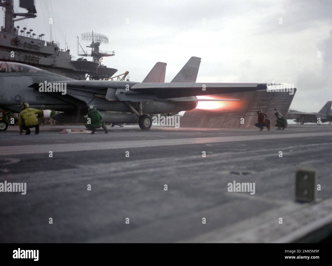 Flight deck crewmen make final preflight checks before launching an F ...
