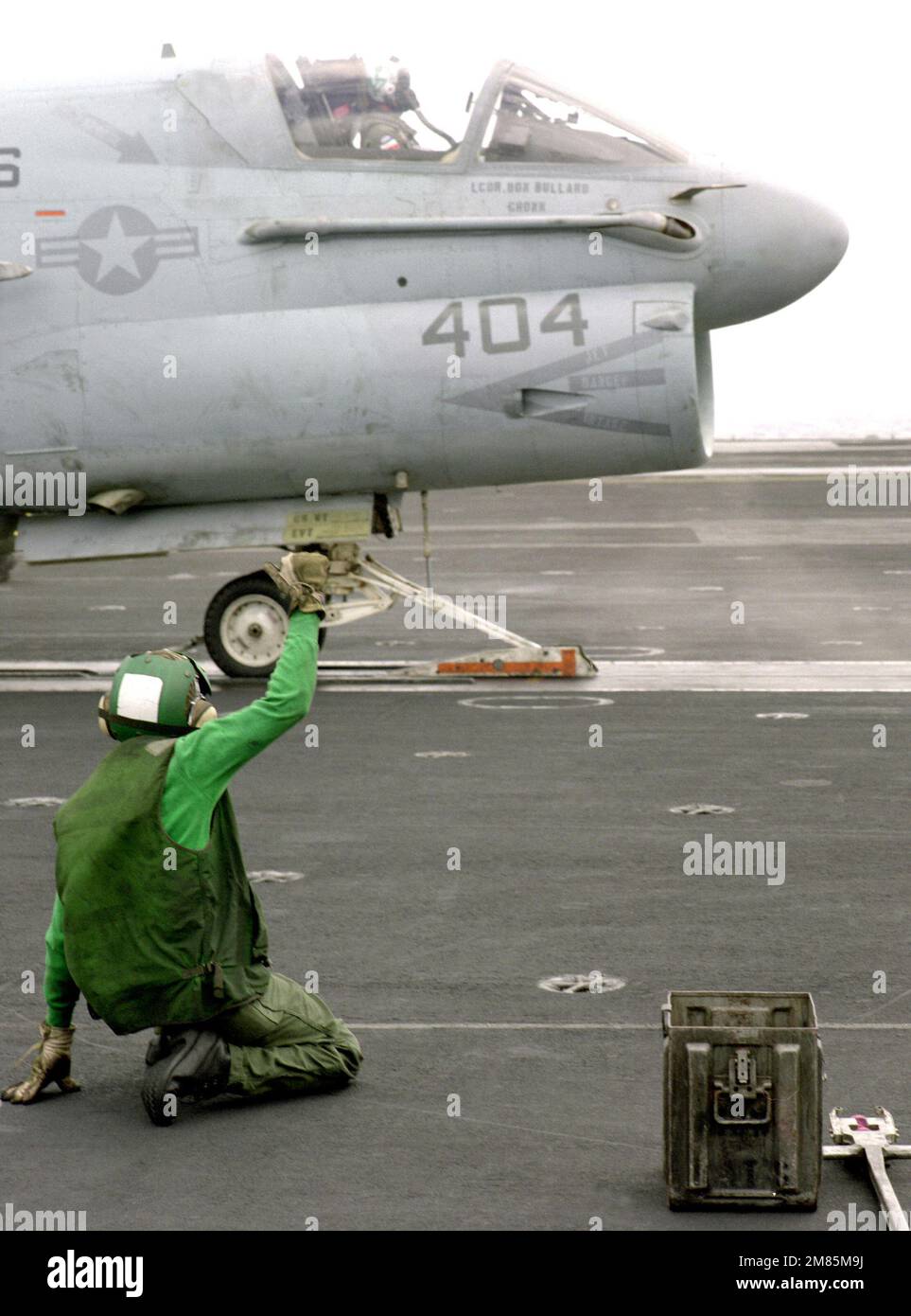 A catapult crewman gives a hand signal while preparing to launch an A ...