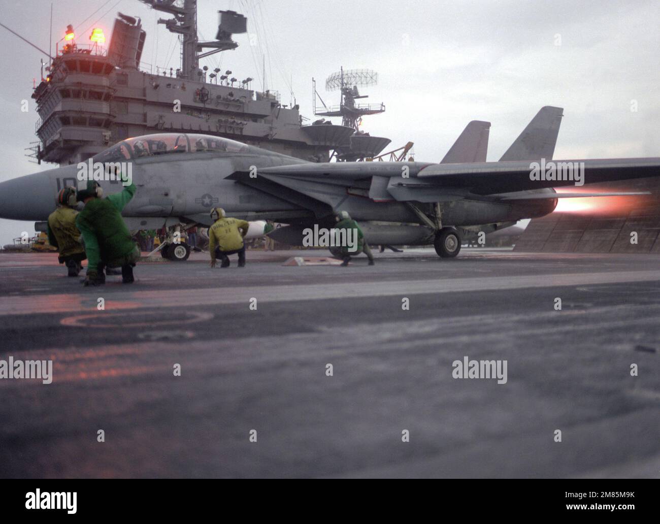 Flight deck crewmen make final preflight checks before launching an F ...