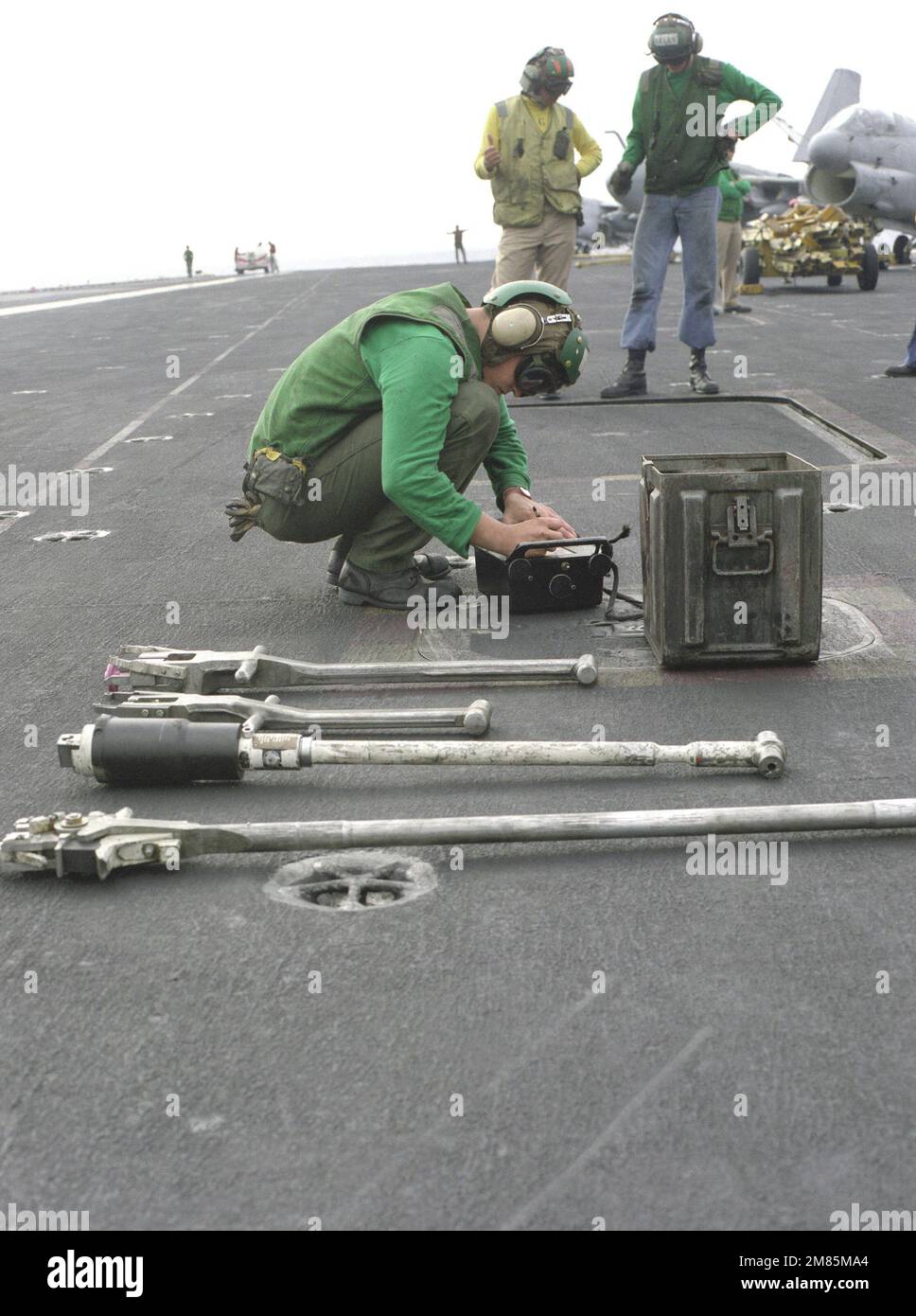 A catapult crewman checks his equipment during flight operations aboard ...