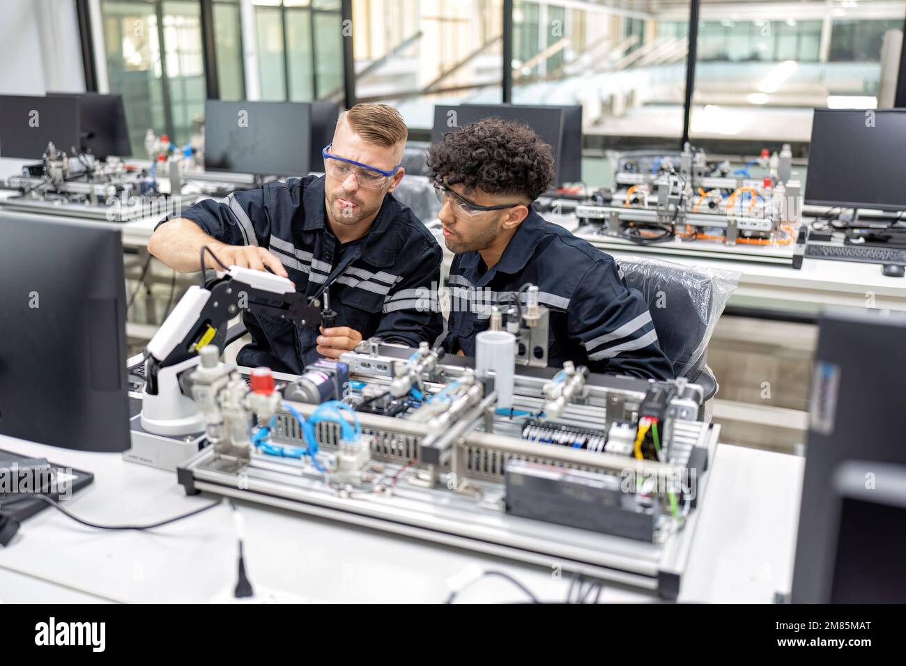 Engineer sitting in robot fabrication room quality checking electronic ...