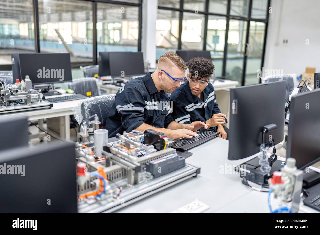 Engineer sitting in robot fabrication room quality checking electronic ...