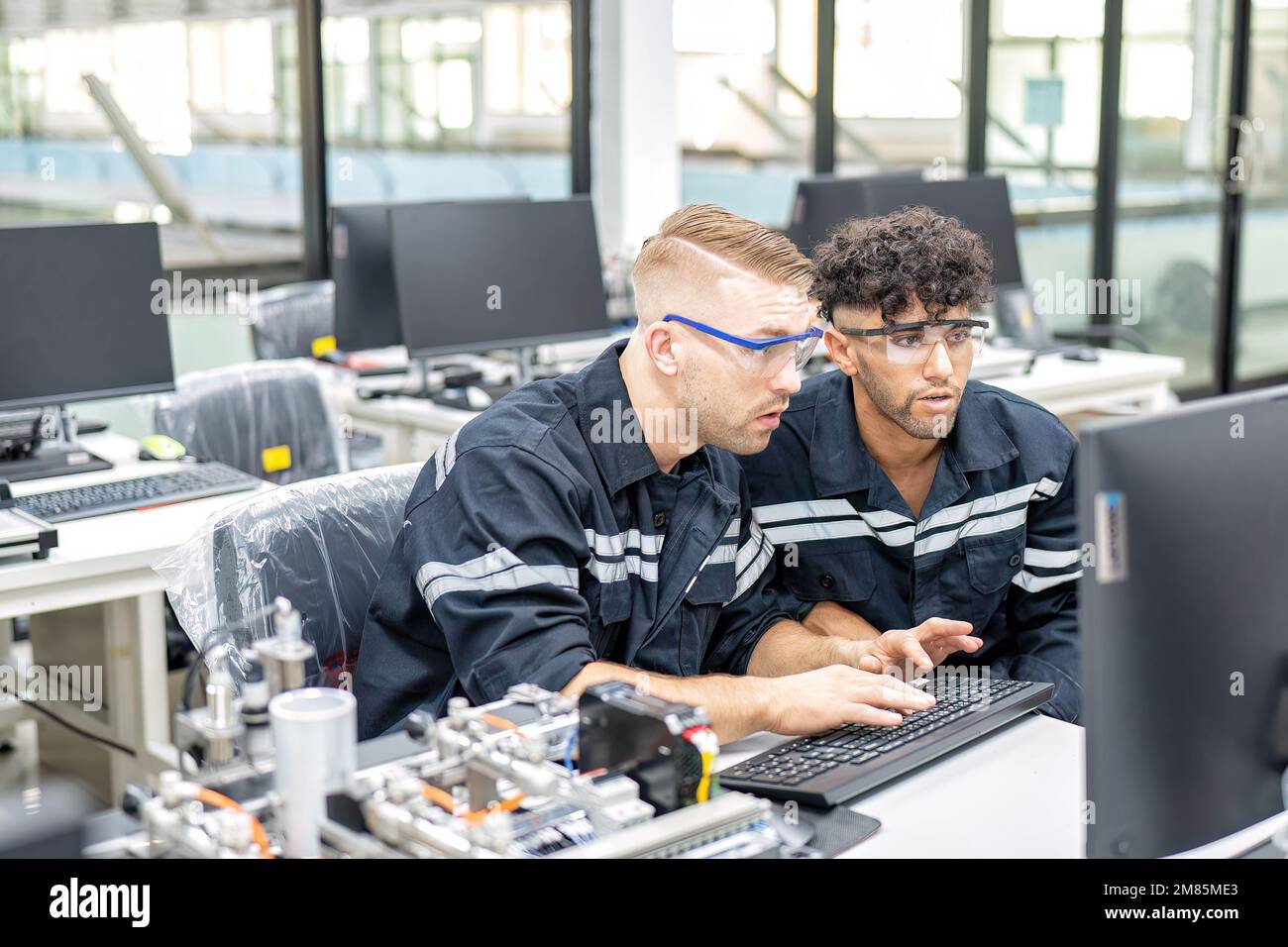 Engineer sitting in robot fabrication room quality checking electronic ...