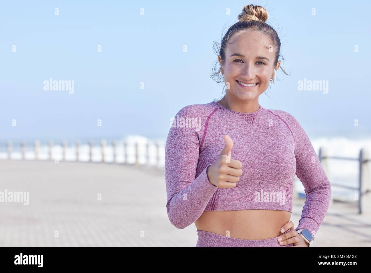Thumbs up, running and like with a sports woman or runner by the beach ...
