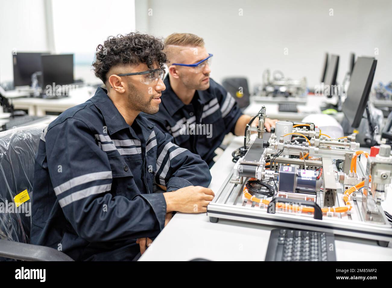 Engineer sitting in robot fabrication room quality checking electronic ...